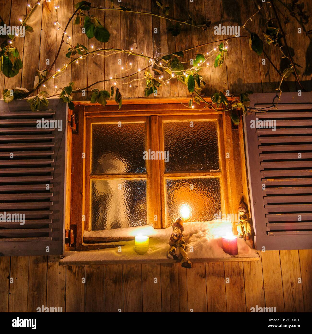 Romantic lightened window of a wooden hut in wintry scenery Stock Photo ...