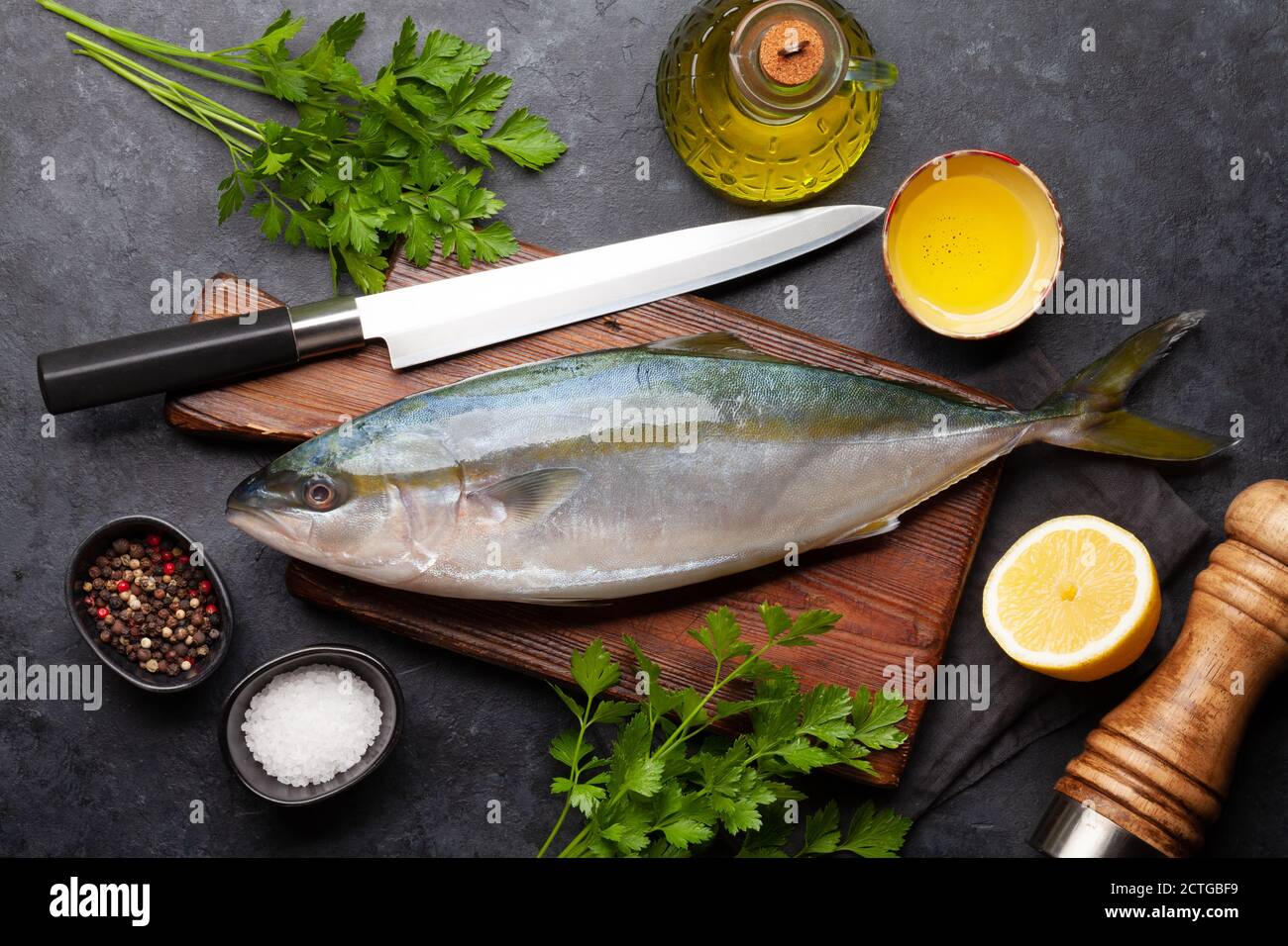 Raw fish cooking. Seafood and ingredients for dinner on stone table ...