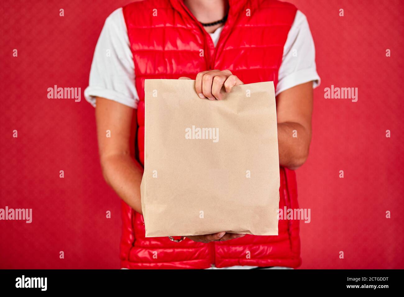 Courier, delivery man in red vest uniform delivers online purchases in ...