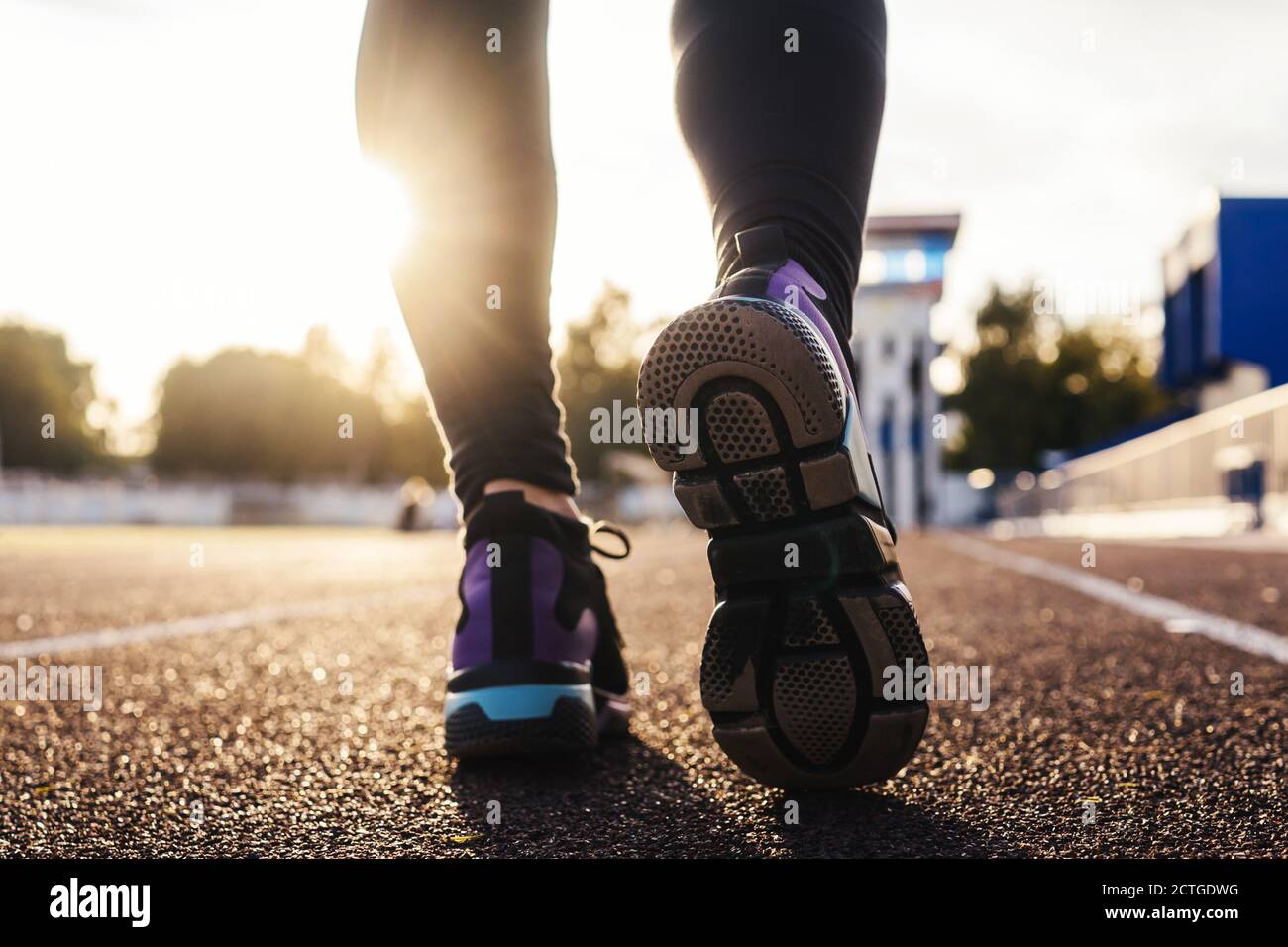 Runner feet running on stadium tracks closeup on shoe. Woman fitness ...