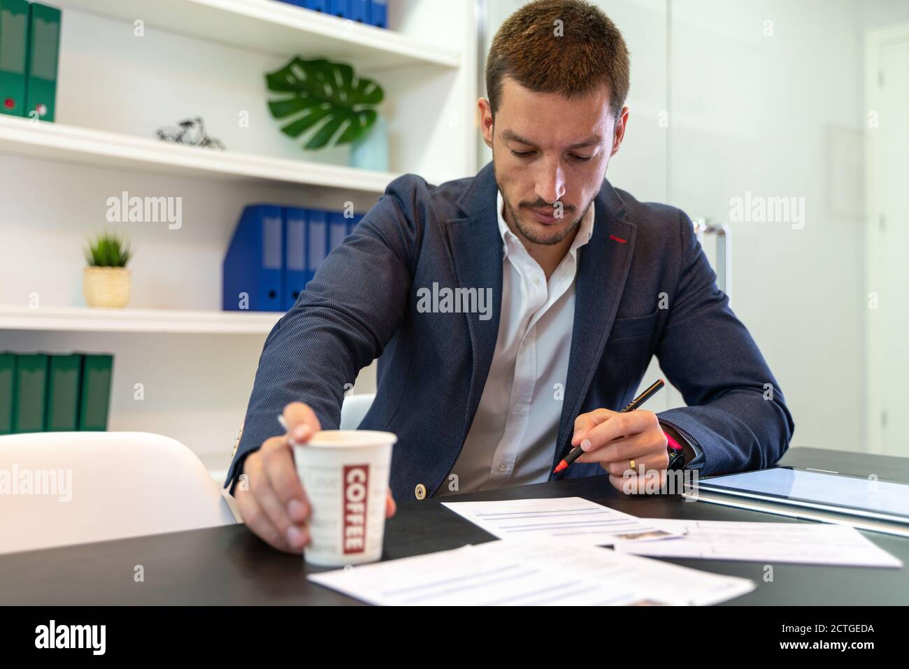 Salesman looking at insurance policy at his office Stock Photo - Alamy