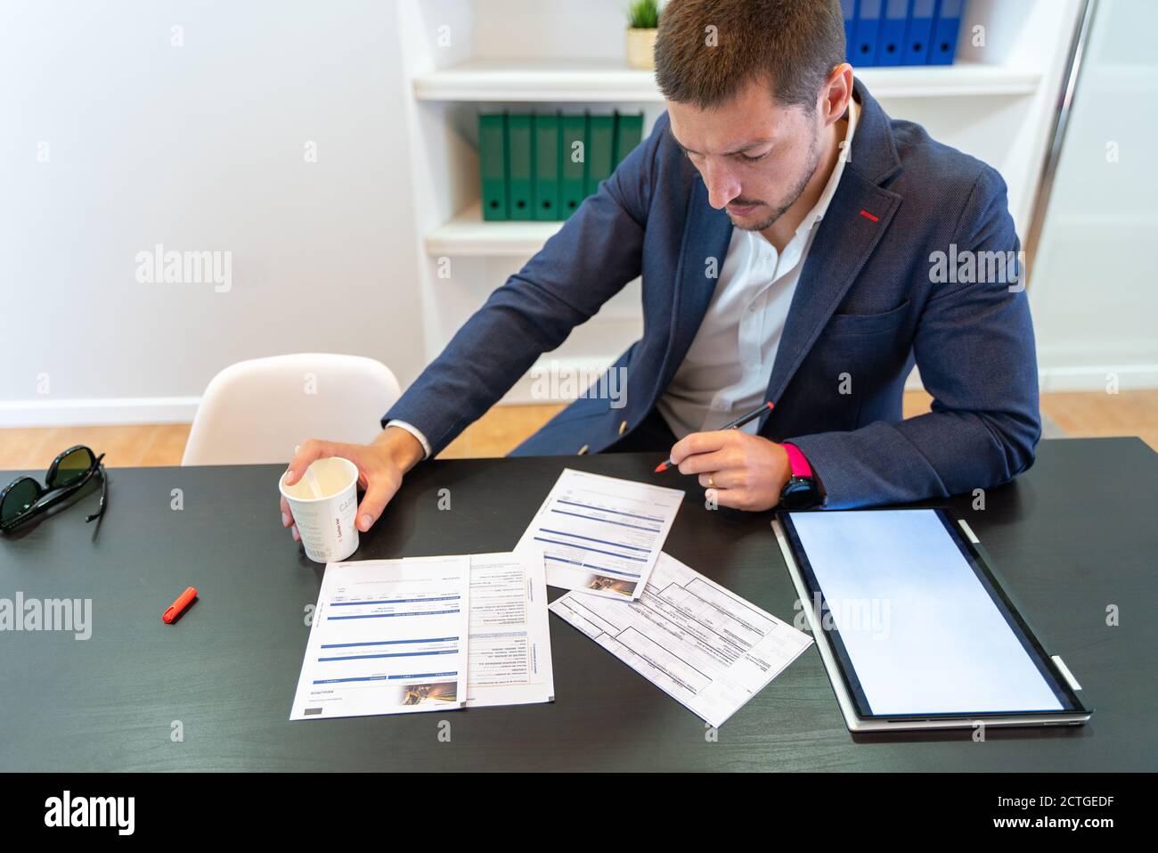 Salesman looking at insurance policy at his office Stock Photo - Alamy