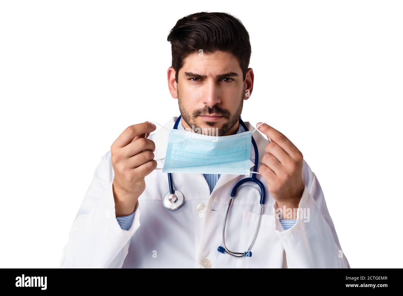 Shot of male doctor putting on face mask while standing at isolated ...