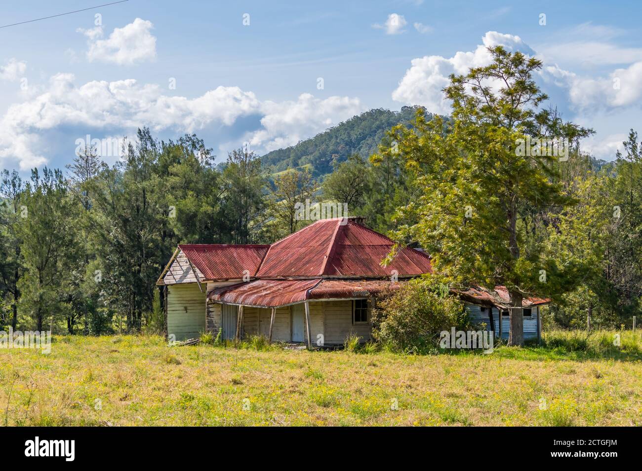 Derelict farm house with red corrugated iron roof set against the ...