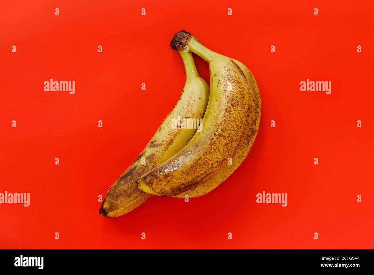 A bunch of very ripe organic bananas on red background top view Stock ...