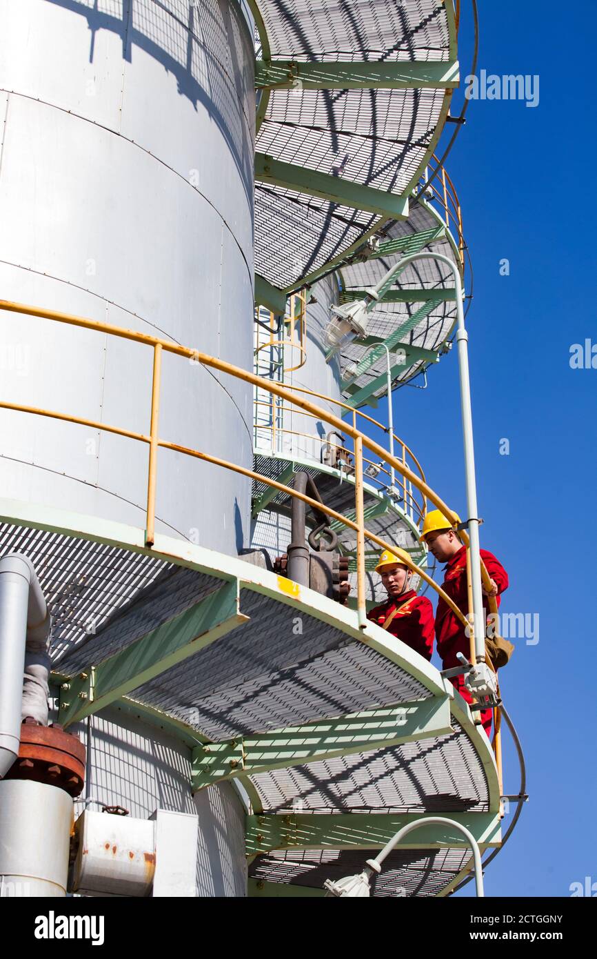Grey distillation column of oil refinery plant on blue sky background ...