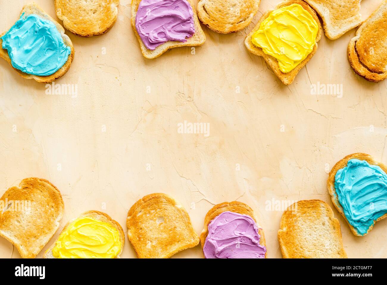 Funny toasted bread with colored cheese spread. Overhead view Stock ...