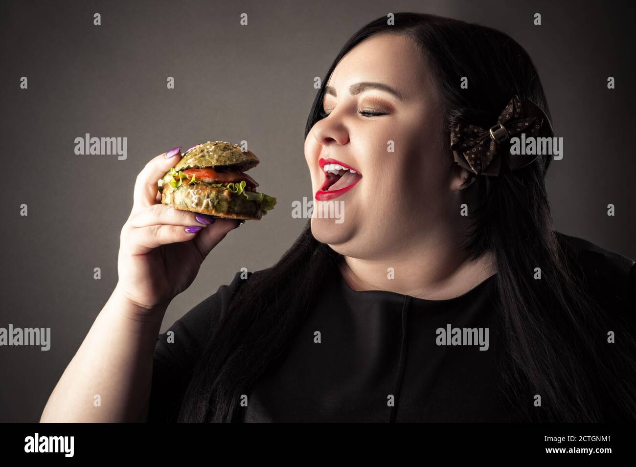 happy portrait fat woman eating hamburger Stock Photo - Alamy