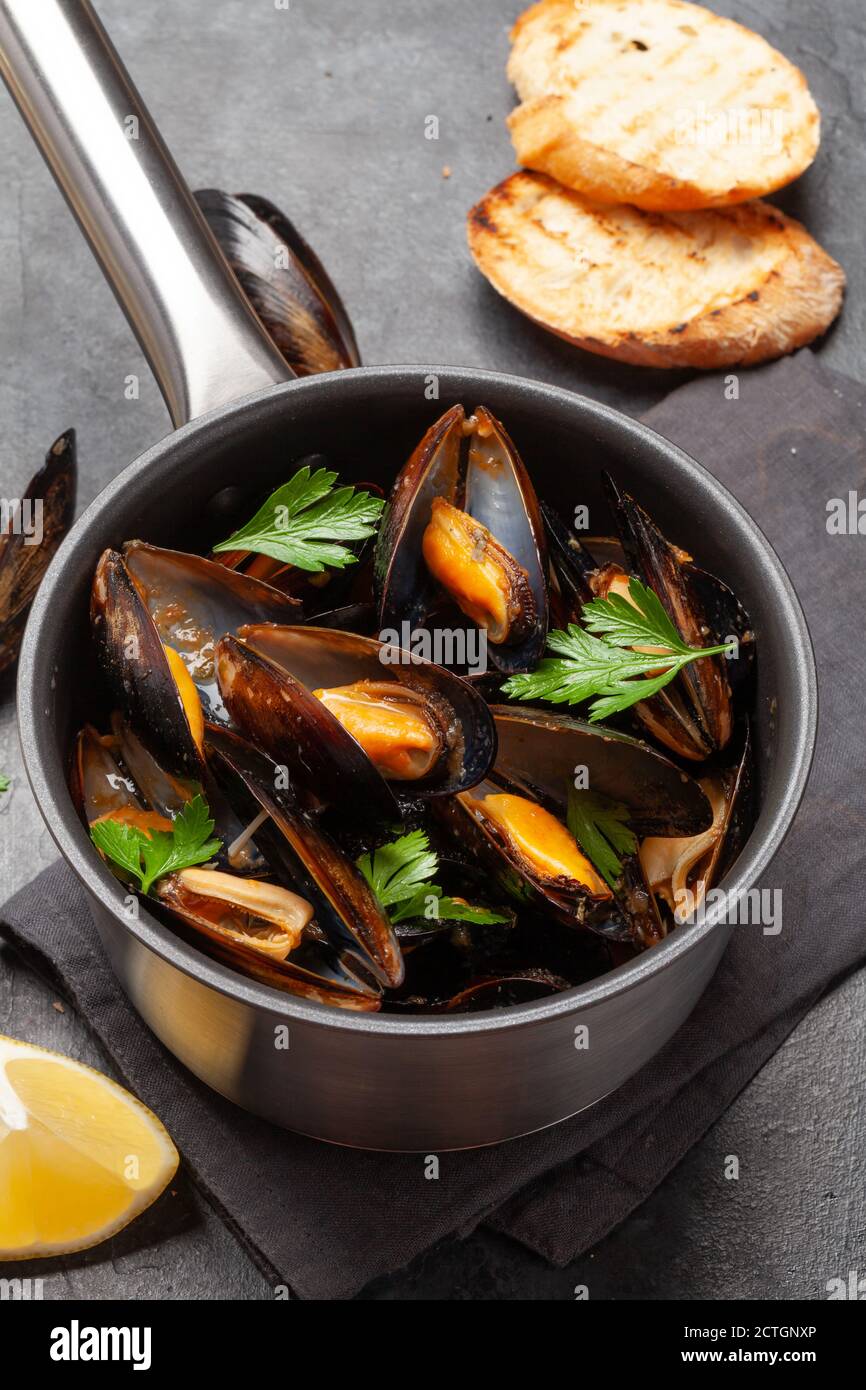 Traditional seafood mussels in wine sauce and toasts Stock Photo - Alamy