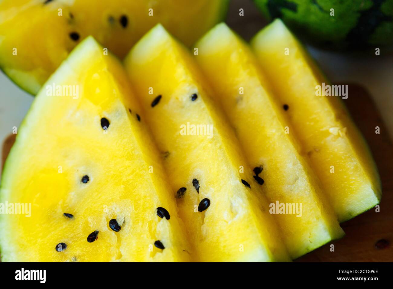 Watermelon with yellow pulp, cut into equal pieces and neatly arranged ...
