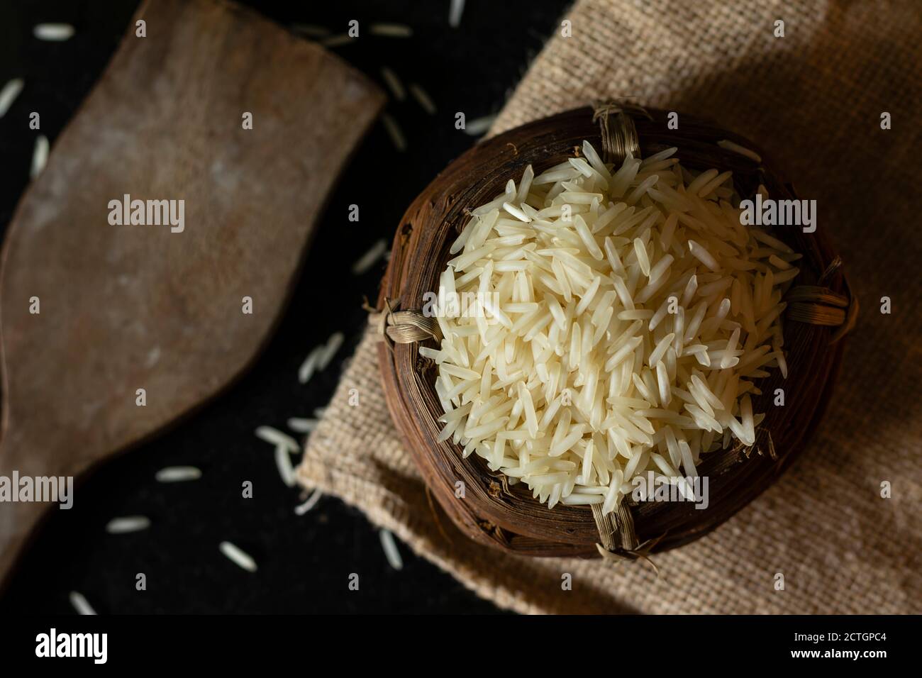 top view of Indian raw basmati rice in a traditional bowl on jute and ...