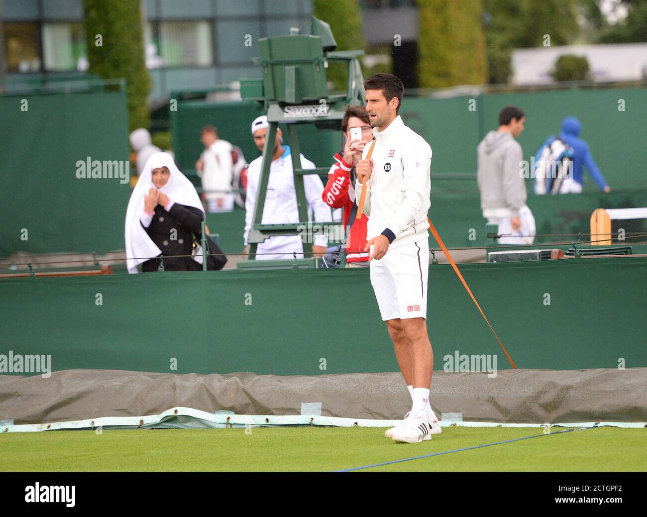 DEFENDING CHAMPION NOVAK DJOKOVIC HELPS THE GROUNDSTAFF PULL ON THE ...