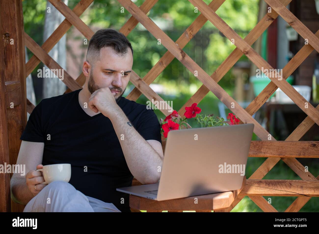 distance working concept. thoughtful young man works with laptop on ...