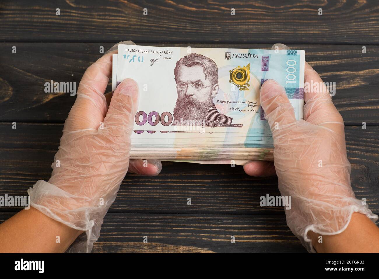Money of Ukraine. Stack of ukrainian hryvnia banknotes in gloved hands ...