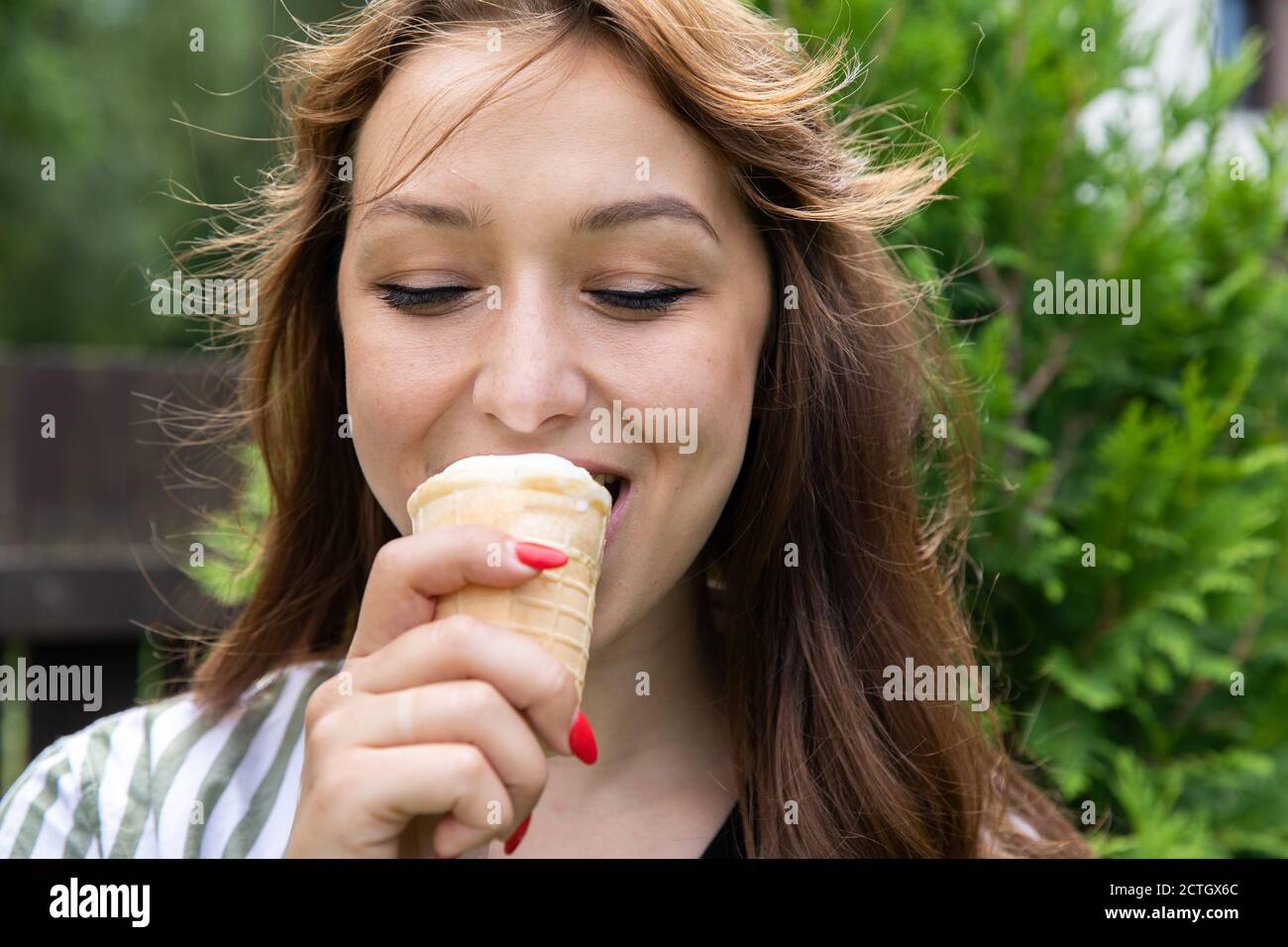 Outdoor close up portrait pretty woman eating ice cream smiling with ...