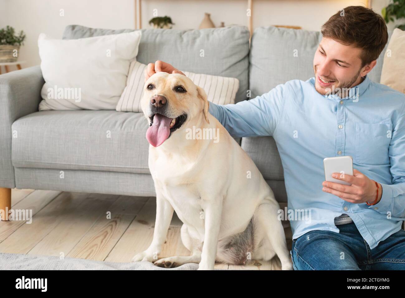 Portrait of guy with his dog using mobile phone Stock Photo - Alamy