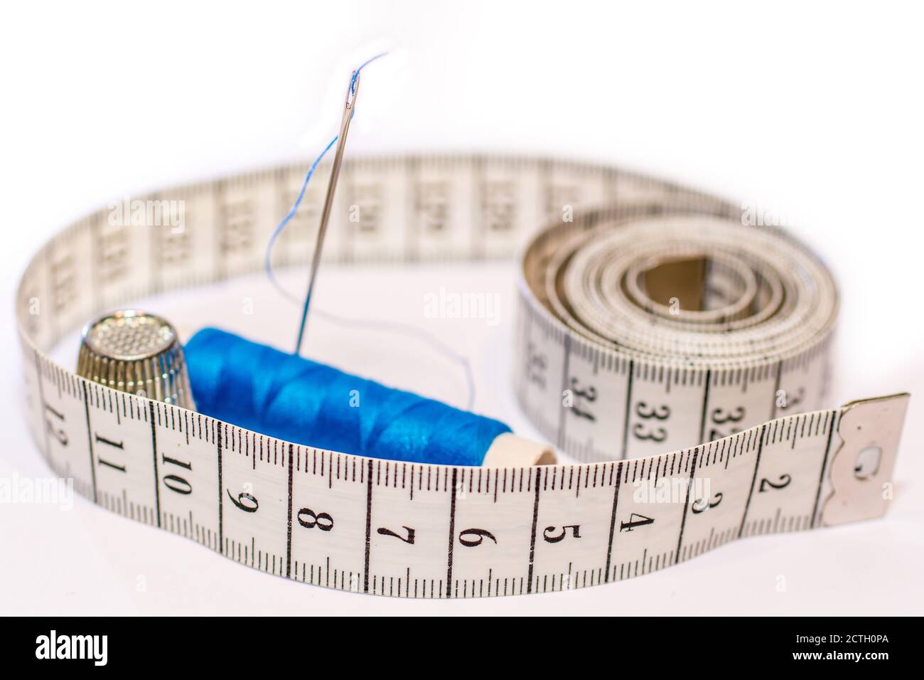 Needle, thread, measuring tape and thimble as a symbol for tailoring ...