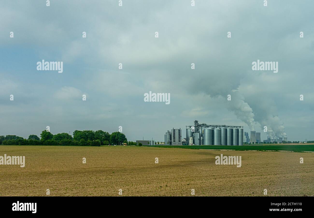 Rural field with factories in the background Stock Photo - Alamy