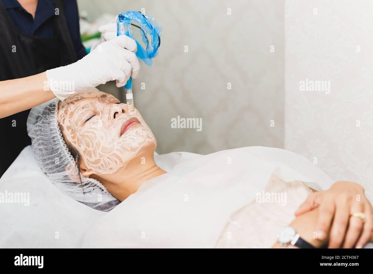 Woman having stimulating facial treatment at professional clinic Stock ...