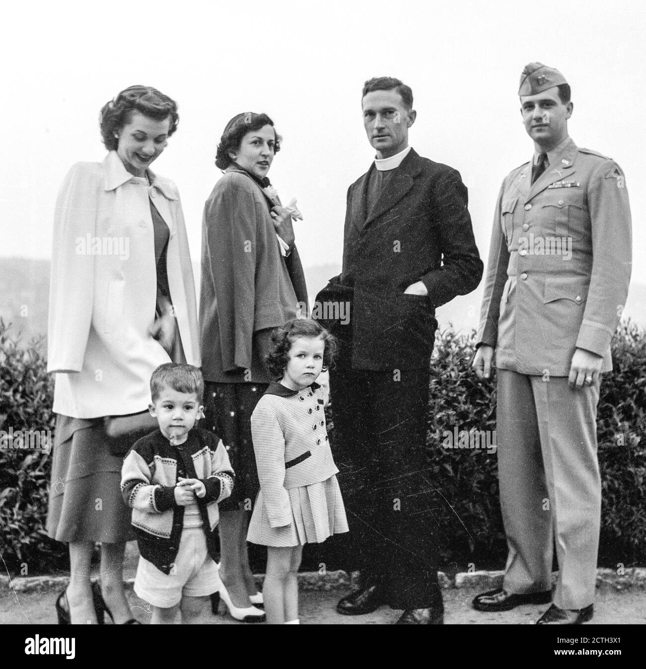 U.S. Military families pose with a priest in occupied Germany, 1950s ...