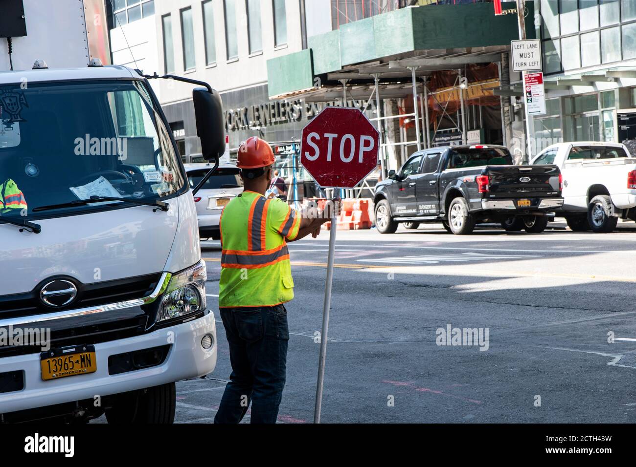 A constructional worker holds a stop sign for the passing cars Stock ...