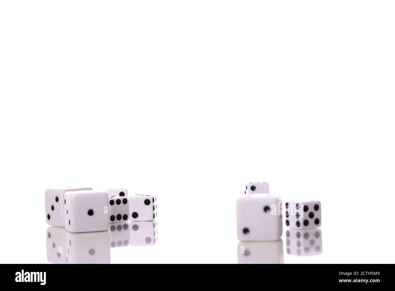 Scattered white dice of different sizes are reflected on table surface ...