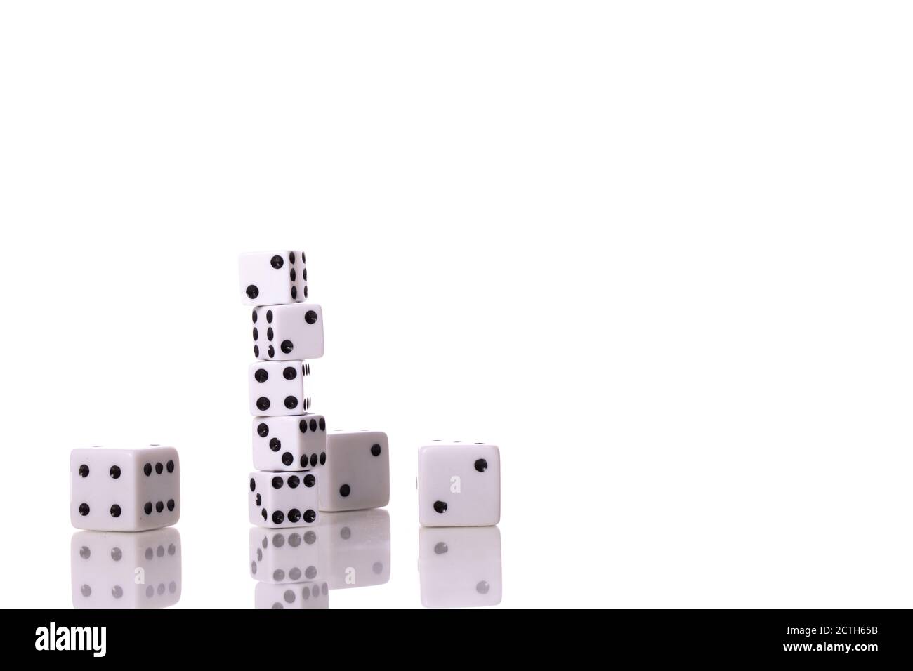 Stack of five white dice and Scattered dice reflected in table surface ...