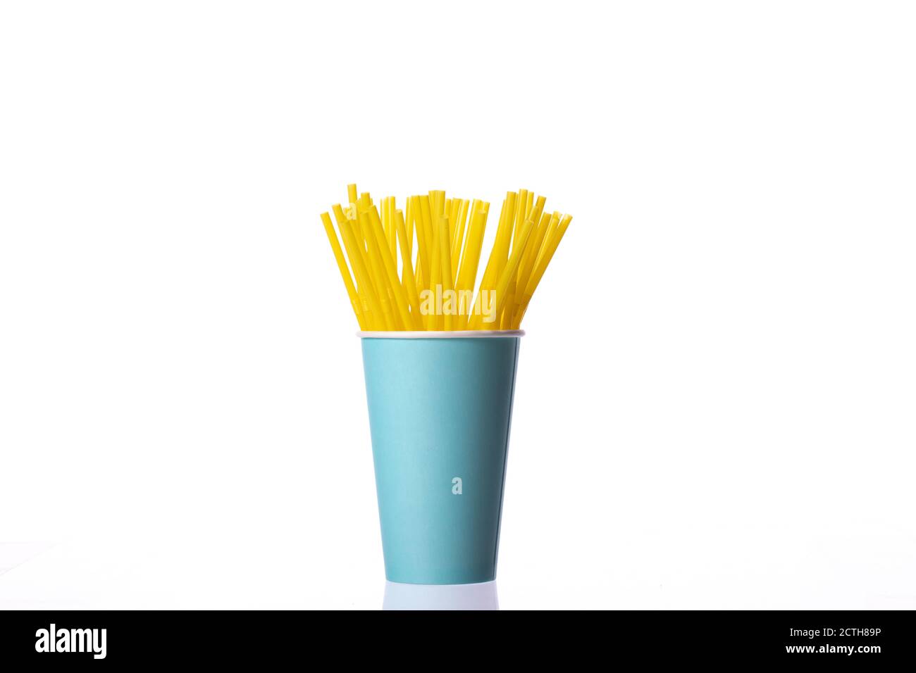 Yellow plastic straws in blue disposable paper cup isolated on white ...