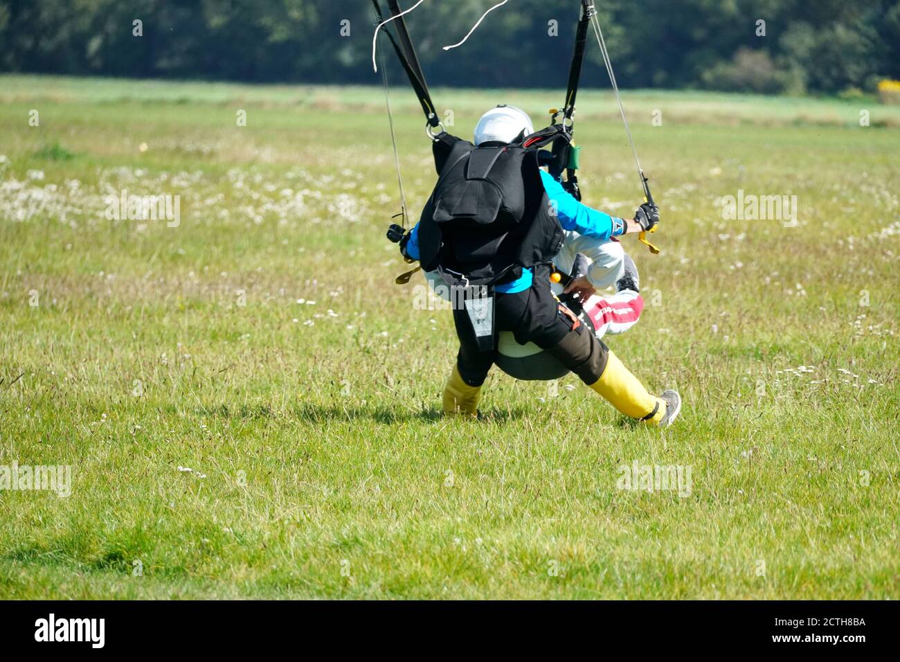 Tandem parachute jump shortly before the moment of landing colourful ...