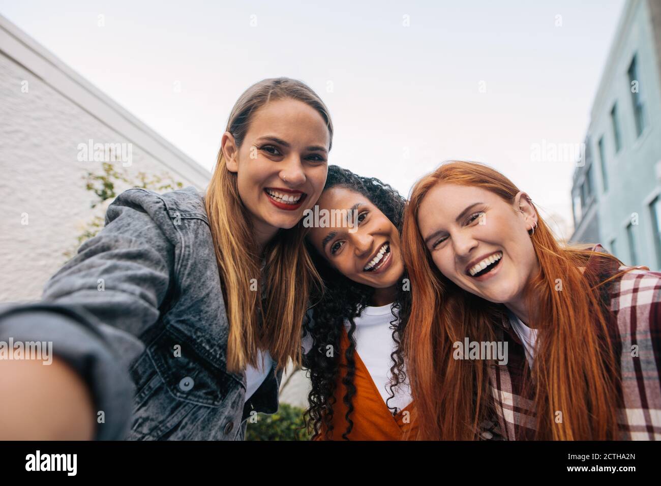 Beautiful young woman talking selfie with friends standing together ...