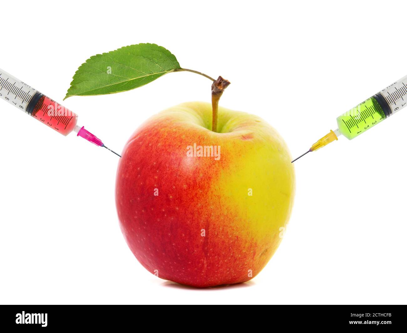 Syringes stuck in an apple. Concept of genetic modification of fruits ...