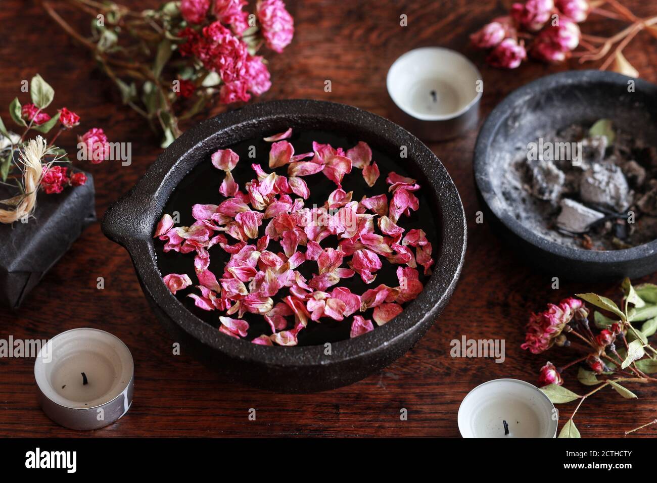 Rose petal infused water on esoteric wiccan witch altar. Pink rose ...