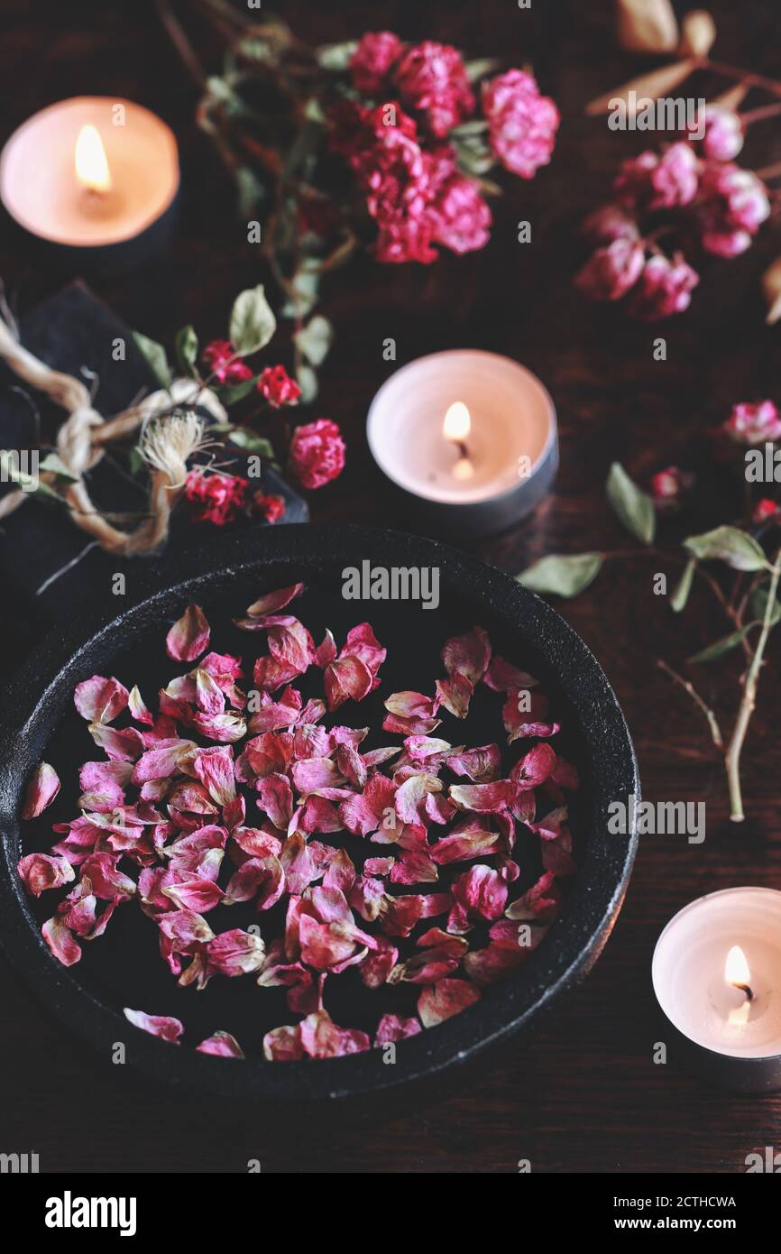 Rose petal infused water on esoteric wiccan witch altar. Pink rose ...