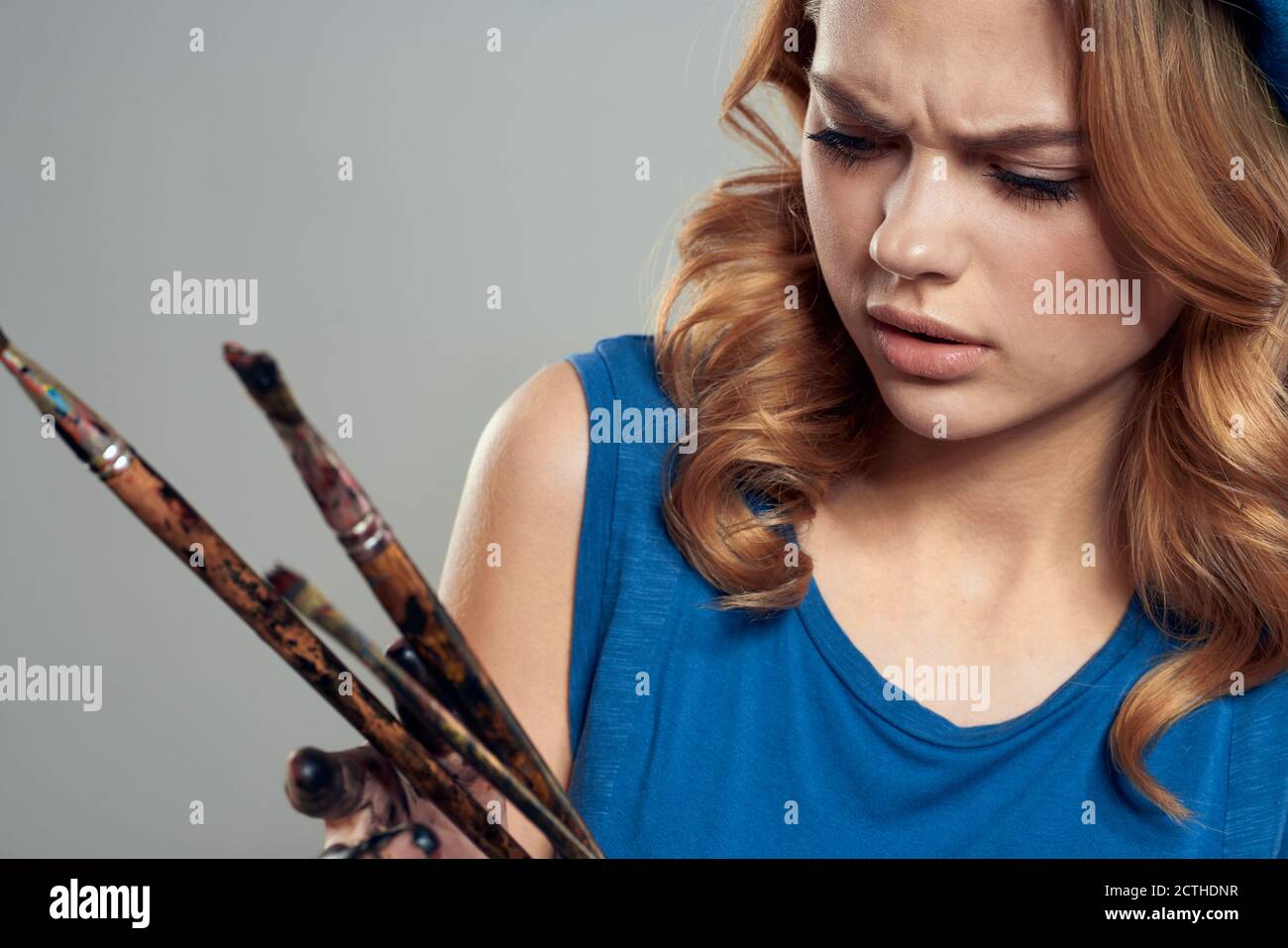 Pretty woman artist paintbrush near face blue beret close-up art Stock ...