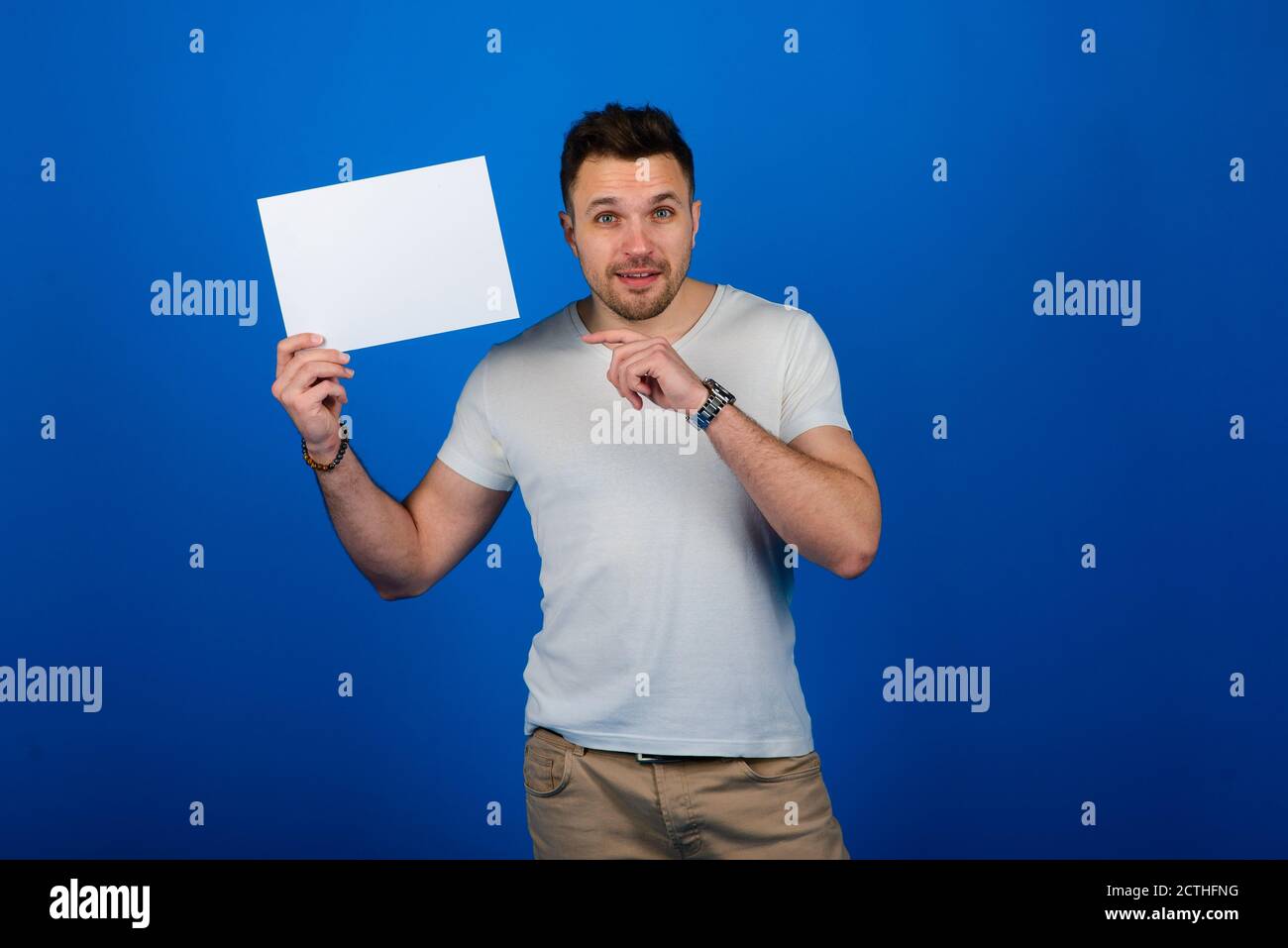 Handsome stylish man standing with a sign in his hand in the studio on ...