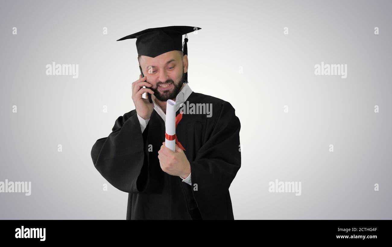 Happy graduated young man in cap and gown talking with a friend Stock ...