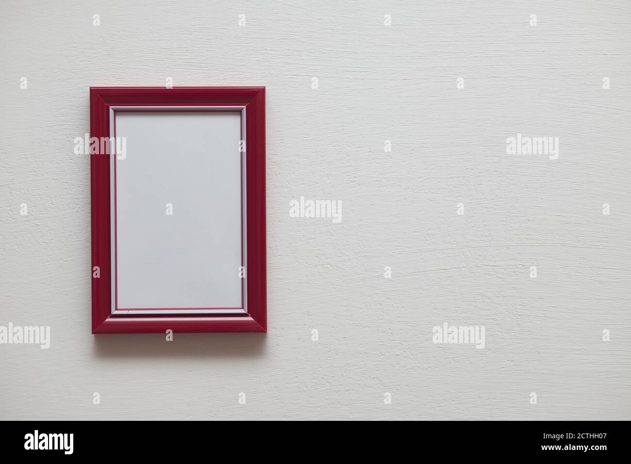 Vertical red plastic frame on indoor white wall Stock Photo - Alamy