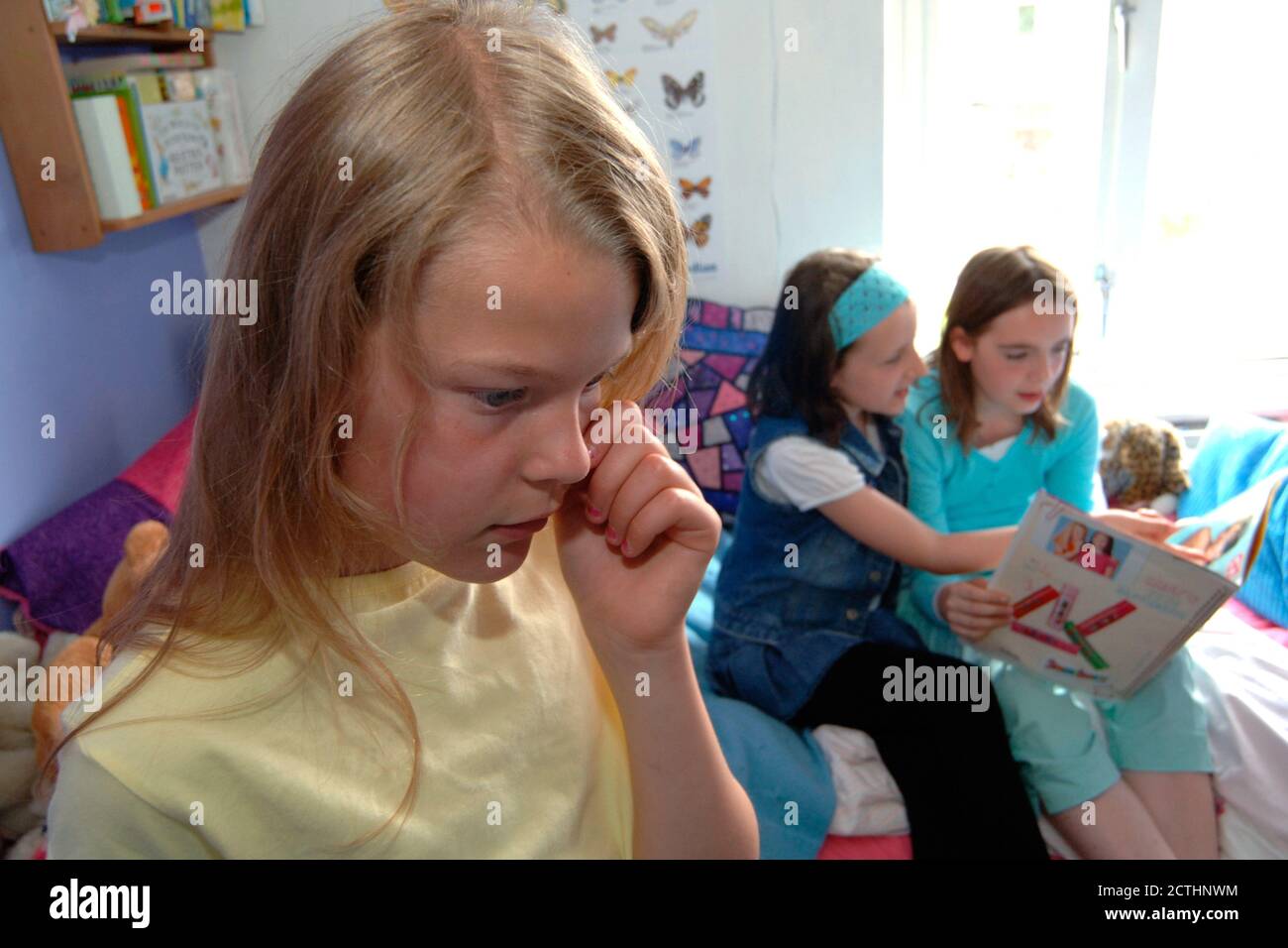 Young girl in her bedroom; separate from her friends Stock Photo - Alamy
