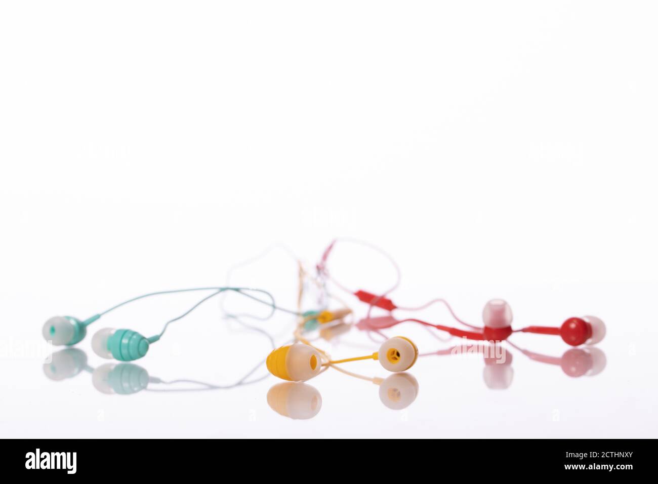 bunch of colorful earphones on white background green, yellow, red ...