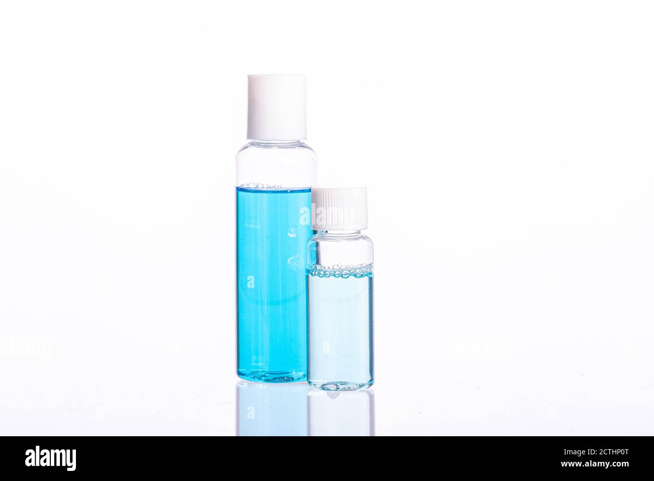 Two transparent containers bottles with liquids isolated on white ...