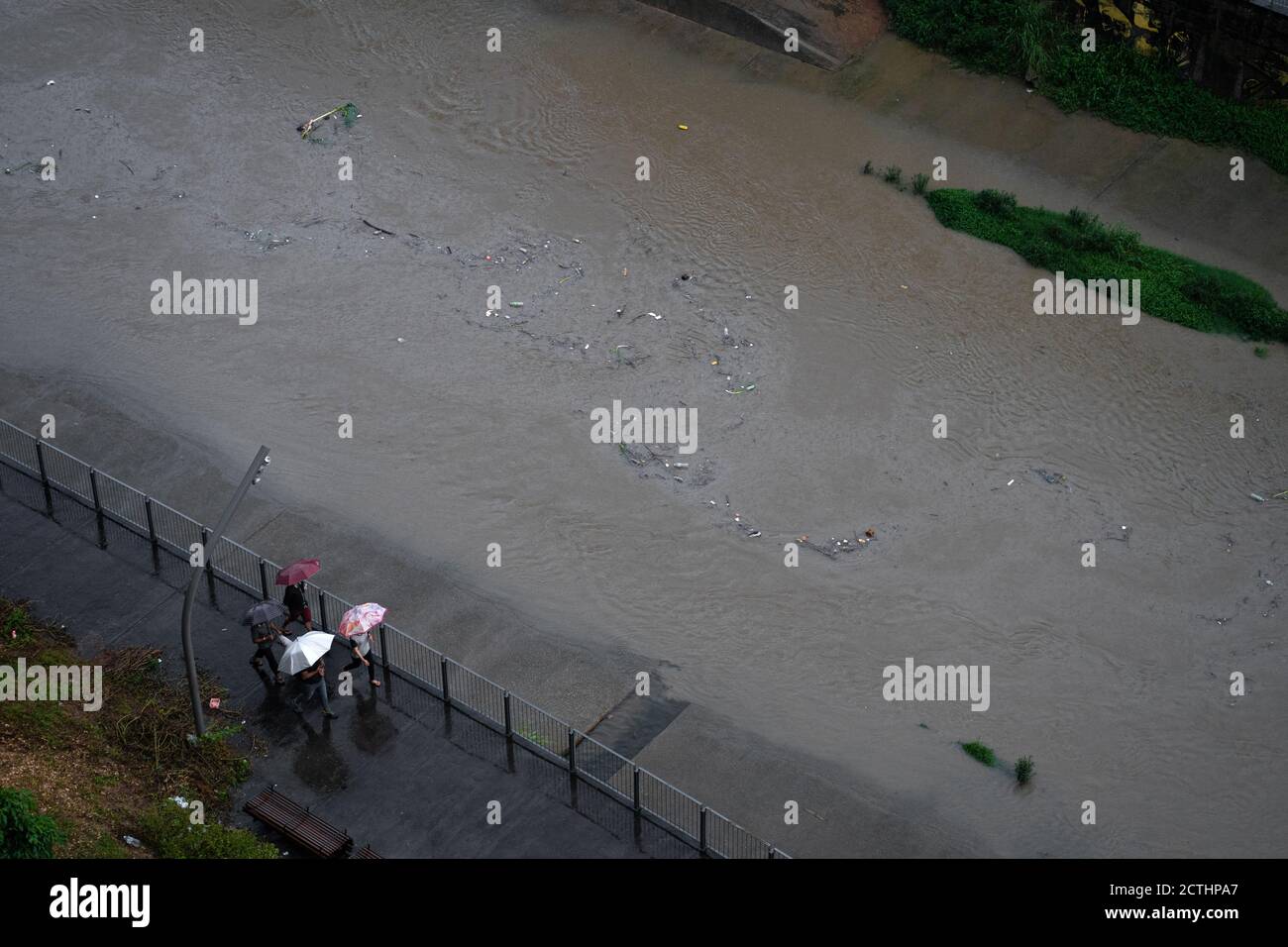 River canal in a big city. Sewage after rain carries garbage along the ...