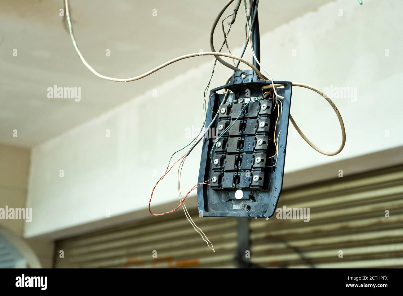 Old broken electricity junction box hanging on wires Stock Photo - Alamy
