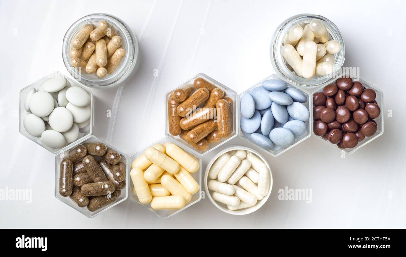 Various medical capsules and tablets in hexagonal jars in the form of ...