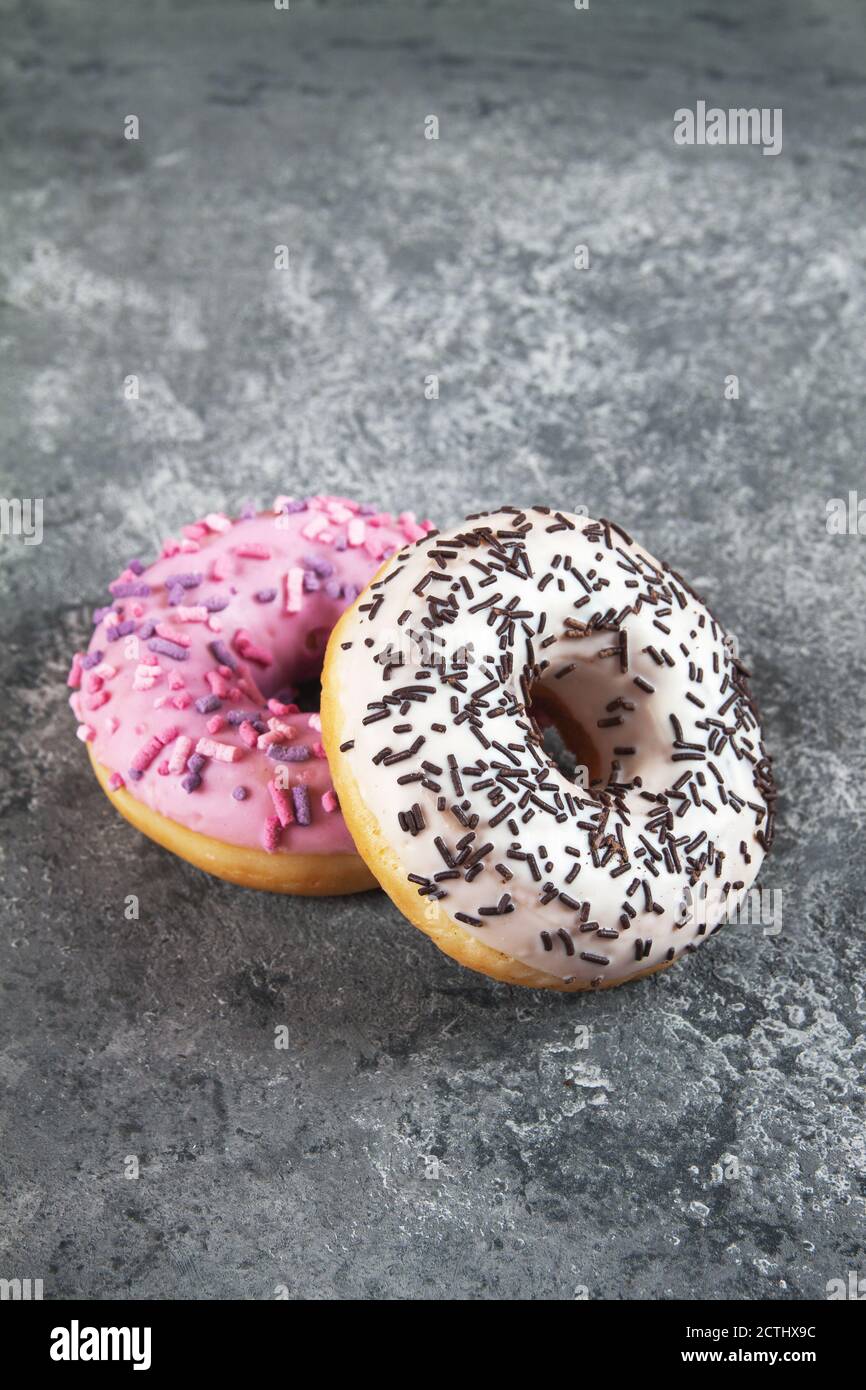 Baked sweet delicious donuts with pastry crumb on gray concrete ...