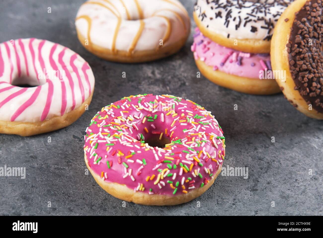 Baked sweet delicious donuts with pastry crumb on gray concrete ...
