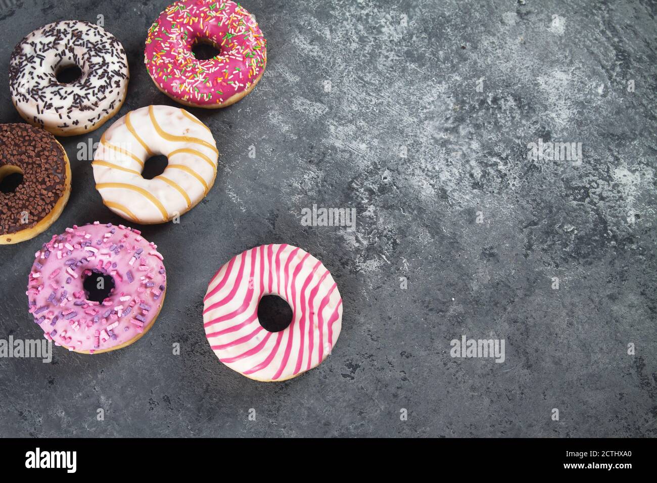 Baked sweet delicious donuts with pastry crumb on gray concrete ...