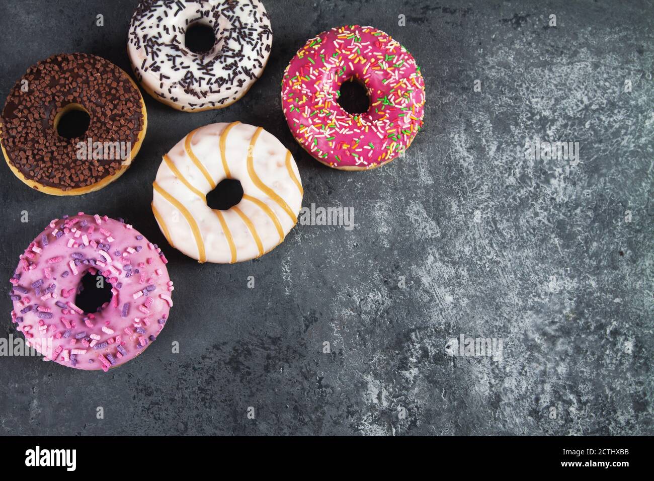 Baked sweet delicious donuts with pastry crumb on gray concrete ...