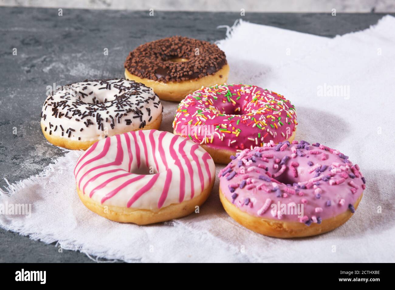 Baked sweet delicious donuts with pastry crumb on gray concrete ...