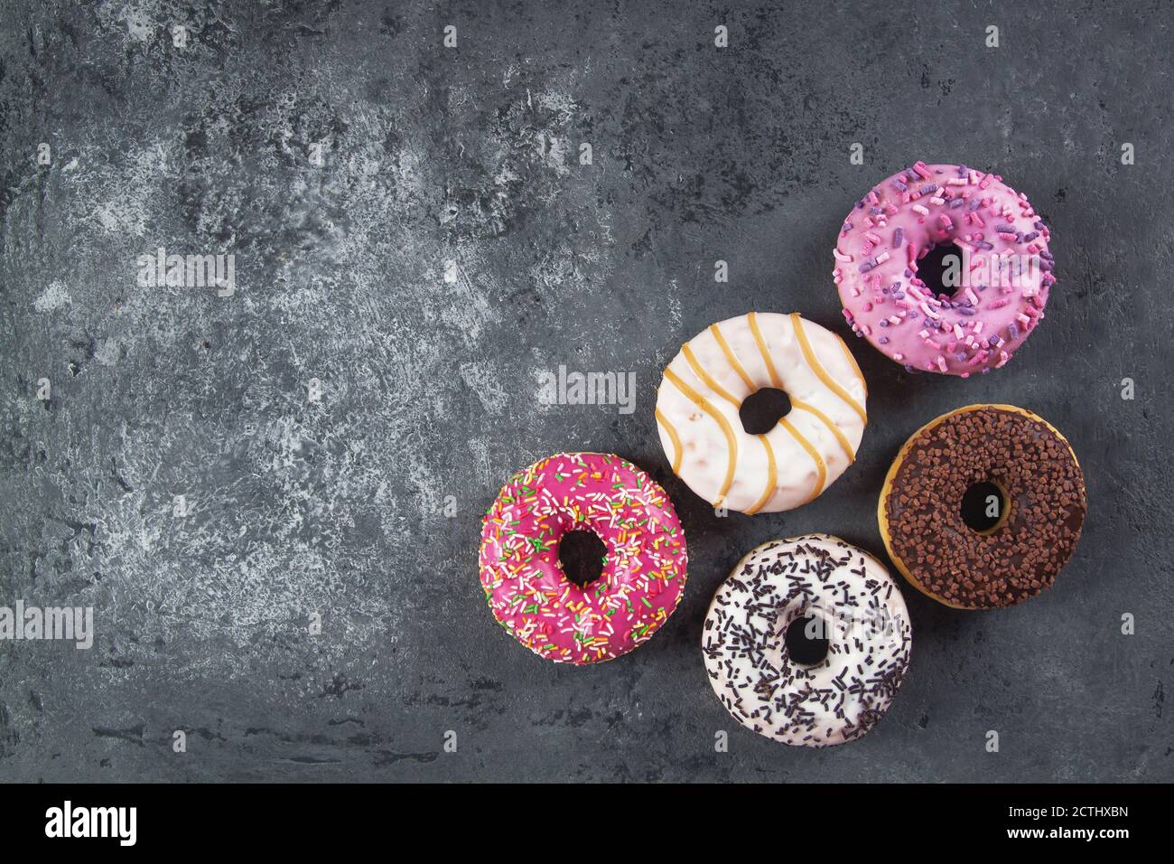 Baked sweet delicious donuts with pastry crumb on gray concrete ...