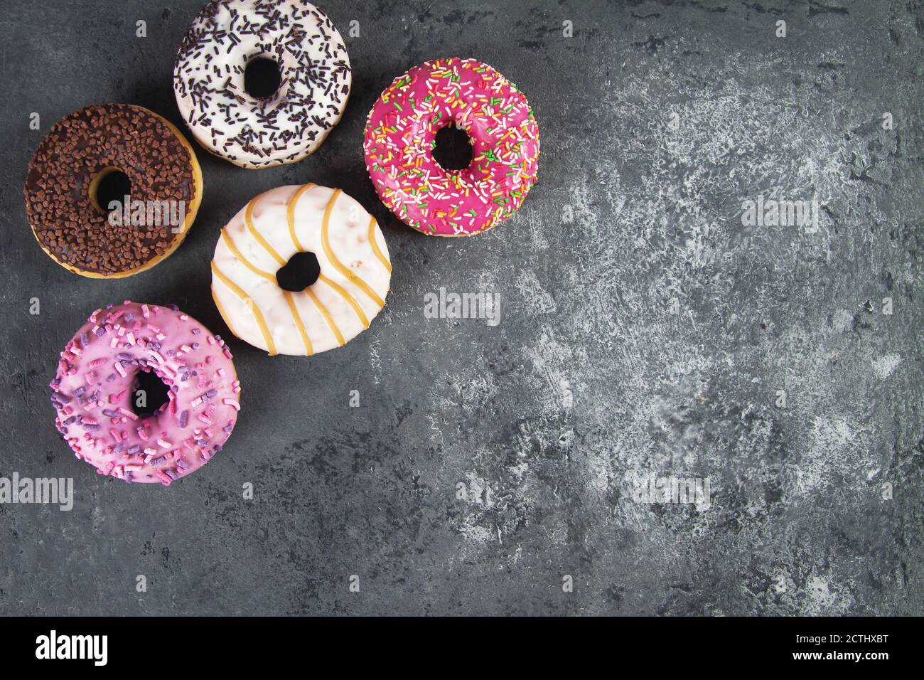 Baked sweet delicious donuts with pastry crumb on gray concrete ...